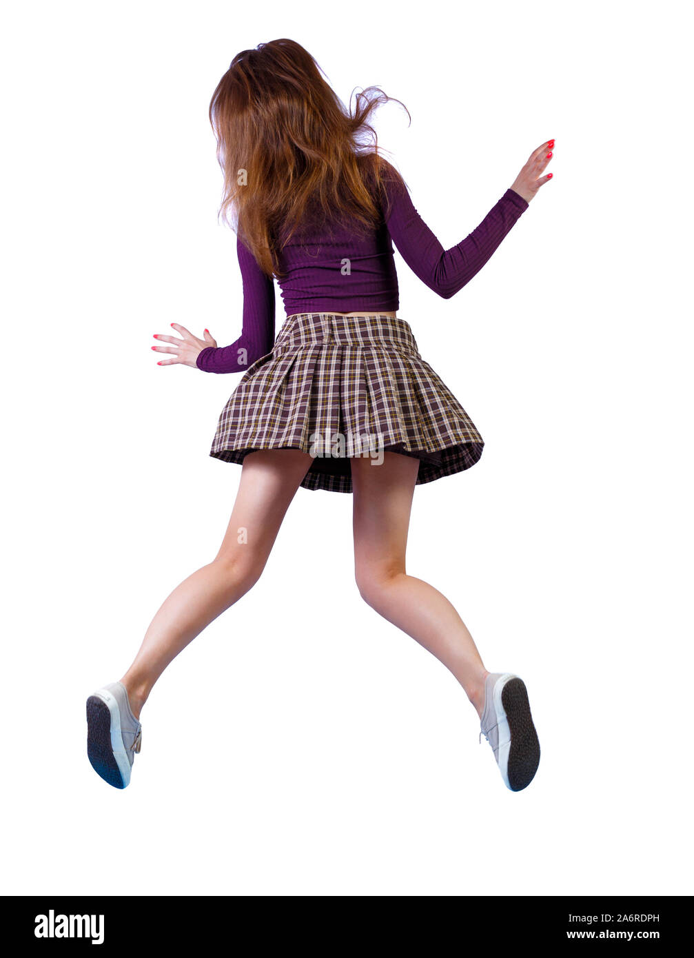 Back view of girl in a jump. Red-haired girl jumps. back side view of ...