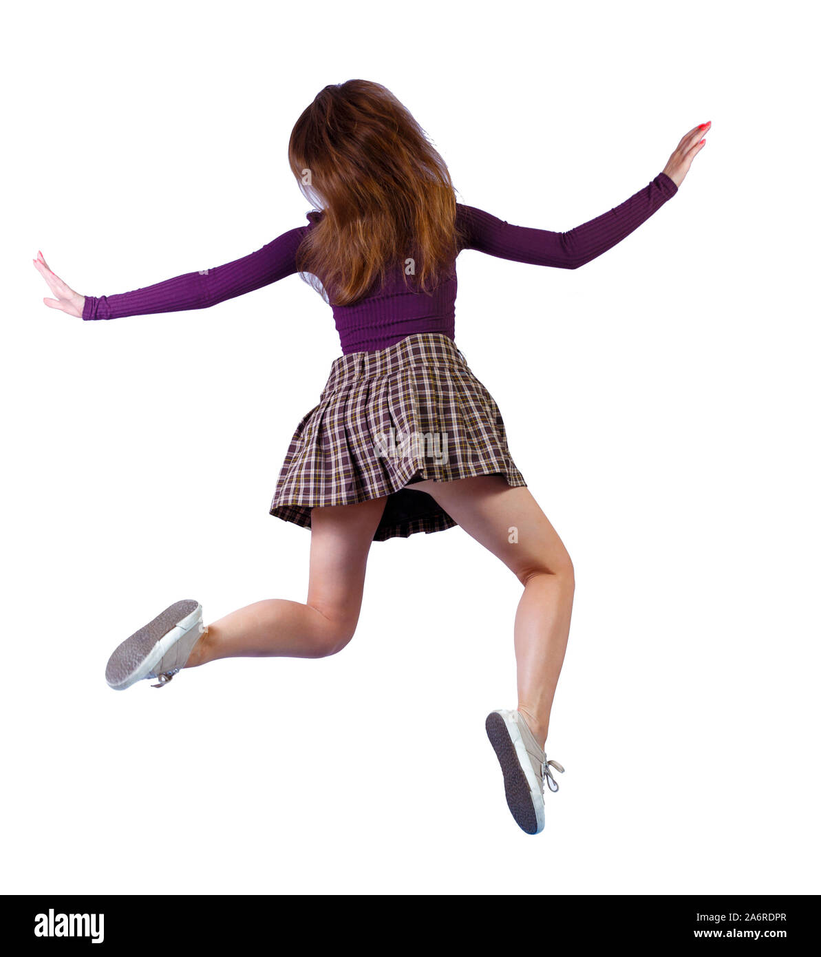Back view of girl in a jump. Red-haired girl jumps. back side view of ...
