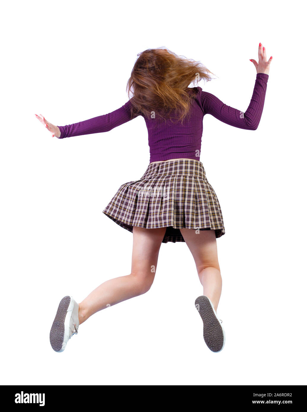 Back view of girl in a jump. Red-haired girl jumps. back side view of ...