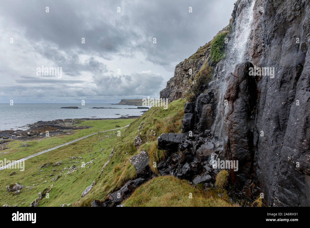 Waterfall overlooking the cliff and Scottish sea on the island of Canna ...