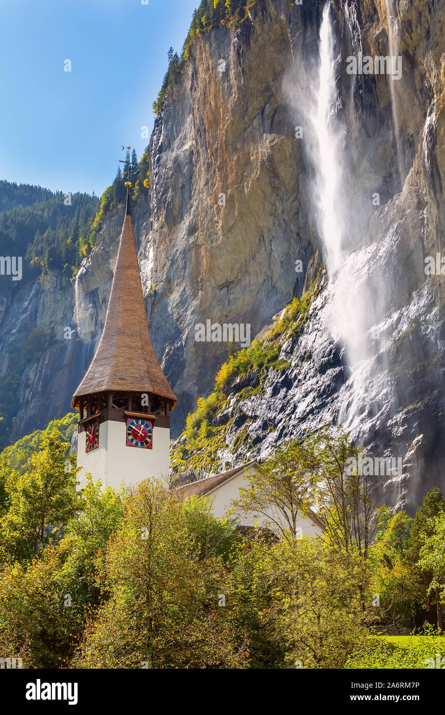 Autumn view of Lauterbrunnen Staubbach Falls waterfall and church tower ...