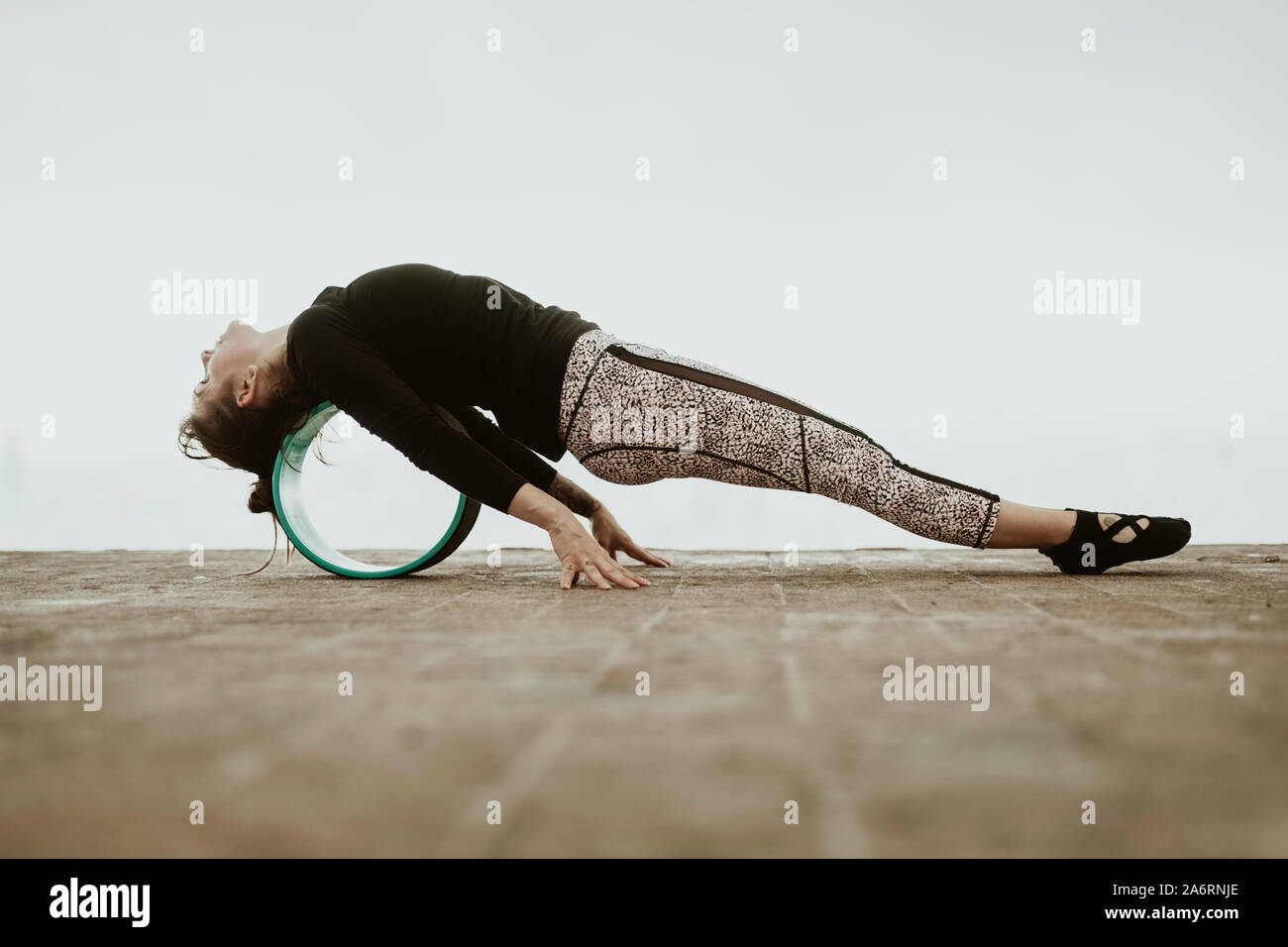Young woman practicing yoga, asana with a roller. Barcelona Stock Photo ...