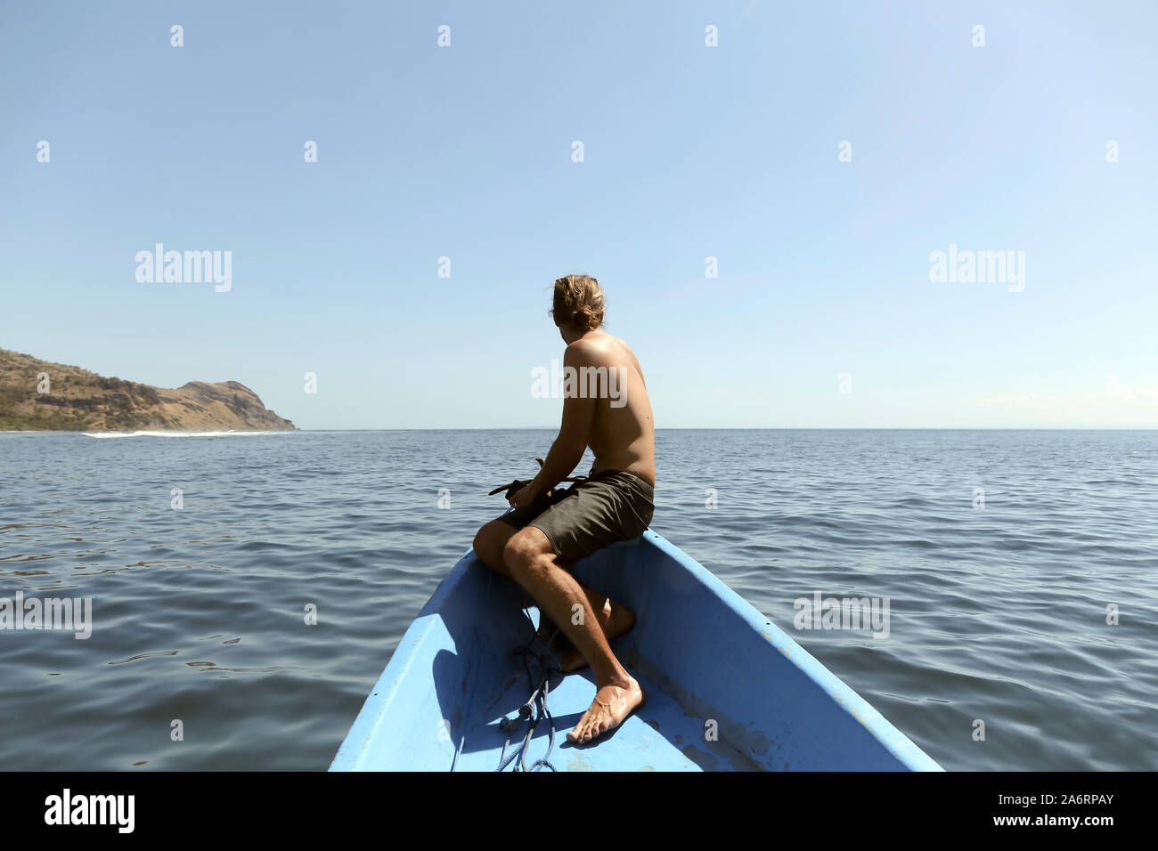 Back view of man sitting on bow of a boat Stock Photo - Alamy