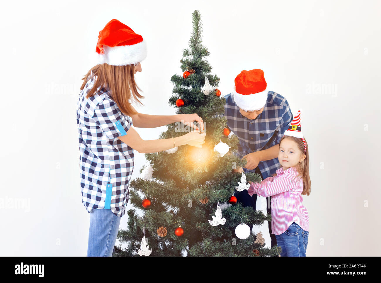 Holidays, parents and celebrating concept - Happy family decorating a ...