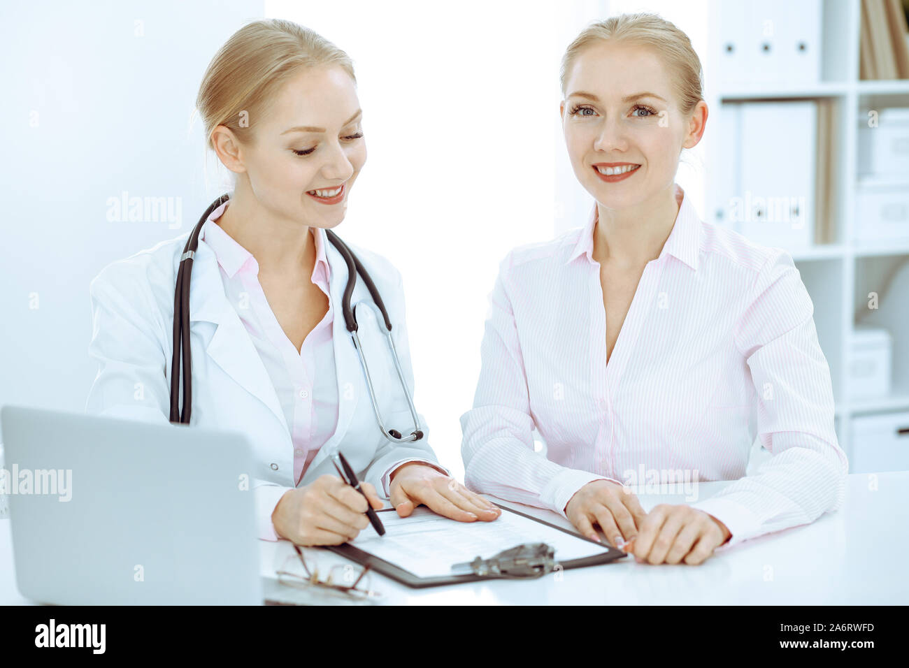 Doctor and patient sitting at the desk. The physician or therapist ...