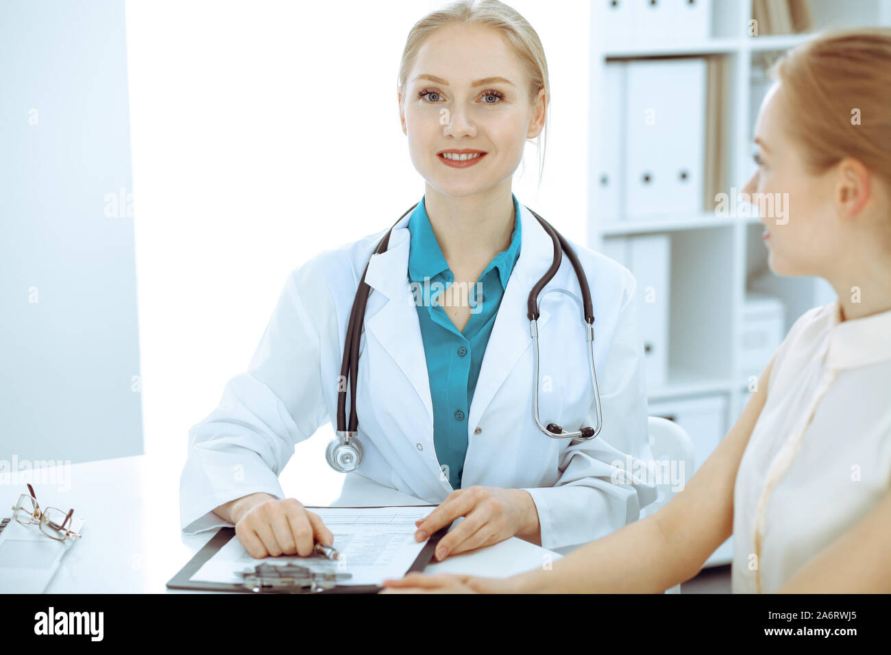 Doctor and patient sitting at the desk. The physician or therapist ...