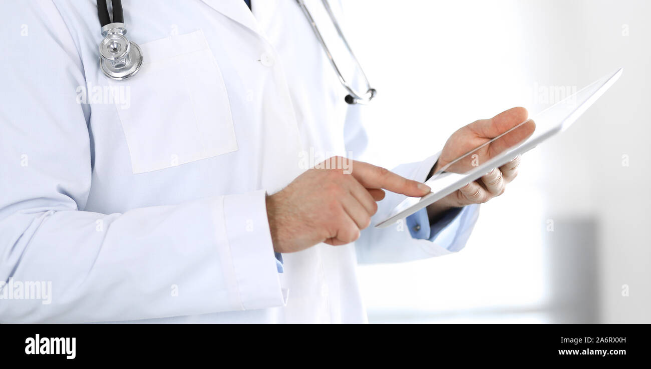 Doctor man using tablet computer for network research or virtual ...