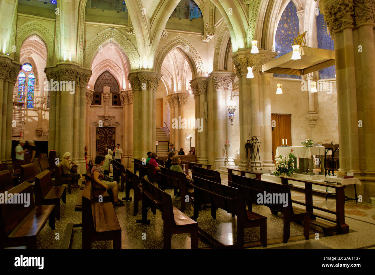 People praying during mass in the crypt of La Sagrada Familia in ...