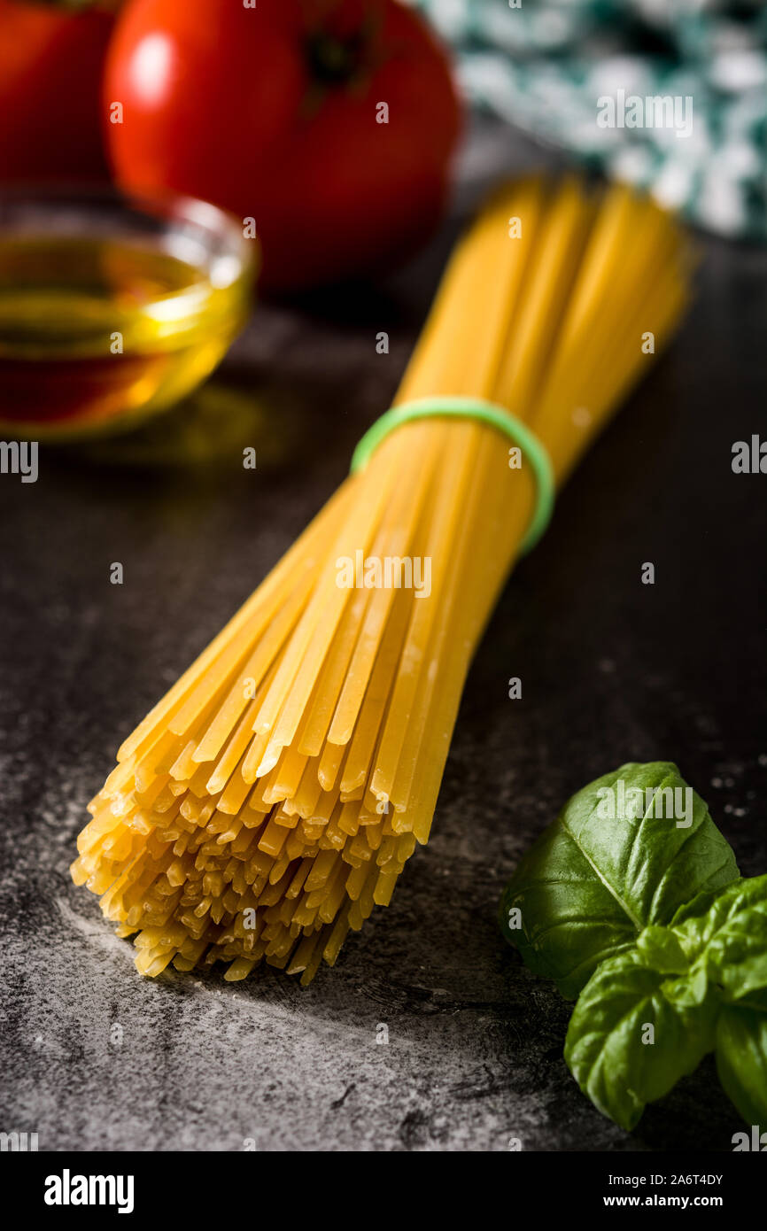 italian food raw spaghetti with ingredients on black background Stock ...