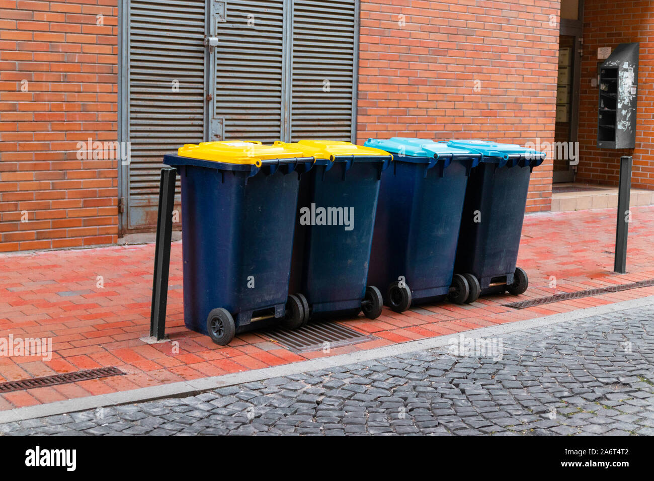 Various plastic garbage containers with colored lids for ...