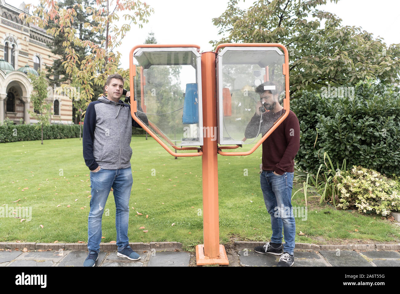 Young man making a a call in a telephone booth Stock Photo - Alamy