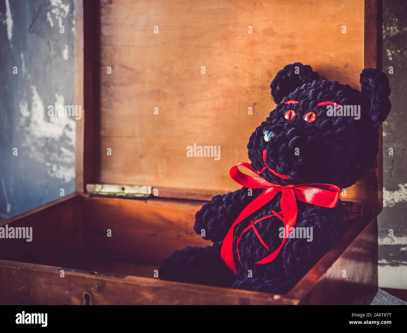 Teddy bear, sitting in a wooden box. Studio photo. Close-up, indoors ...