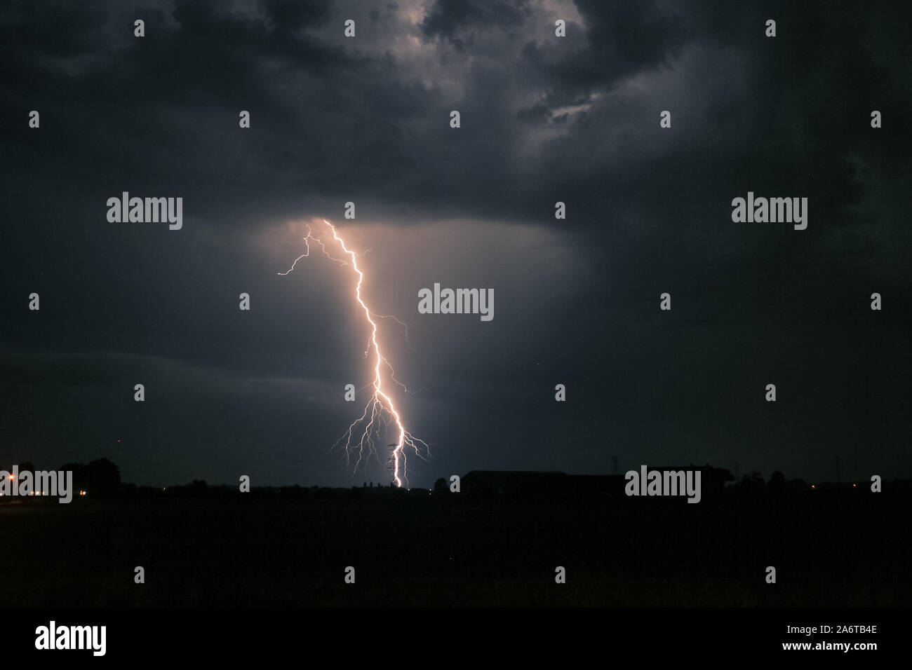 Bright branched lightning strike near an electricity mast from a severe ...