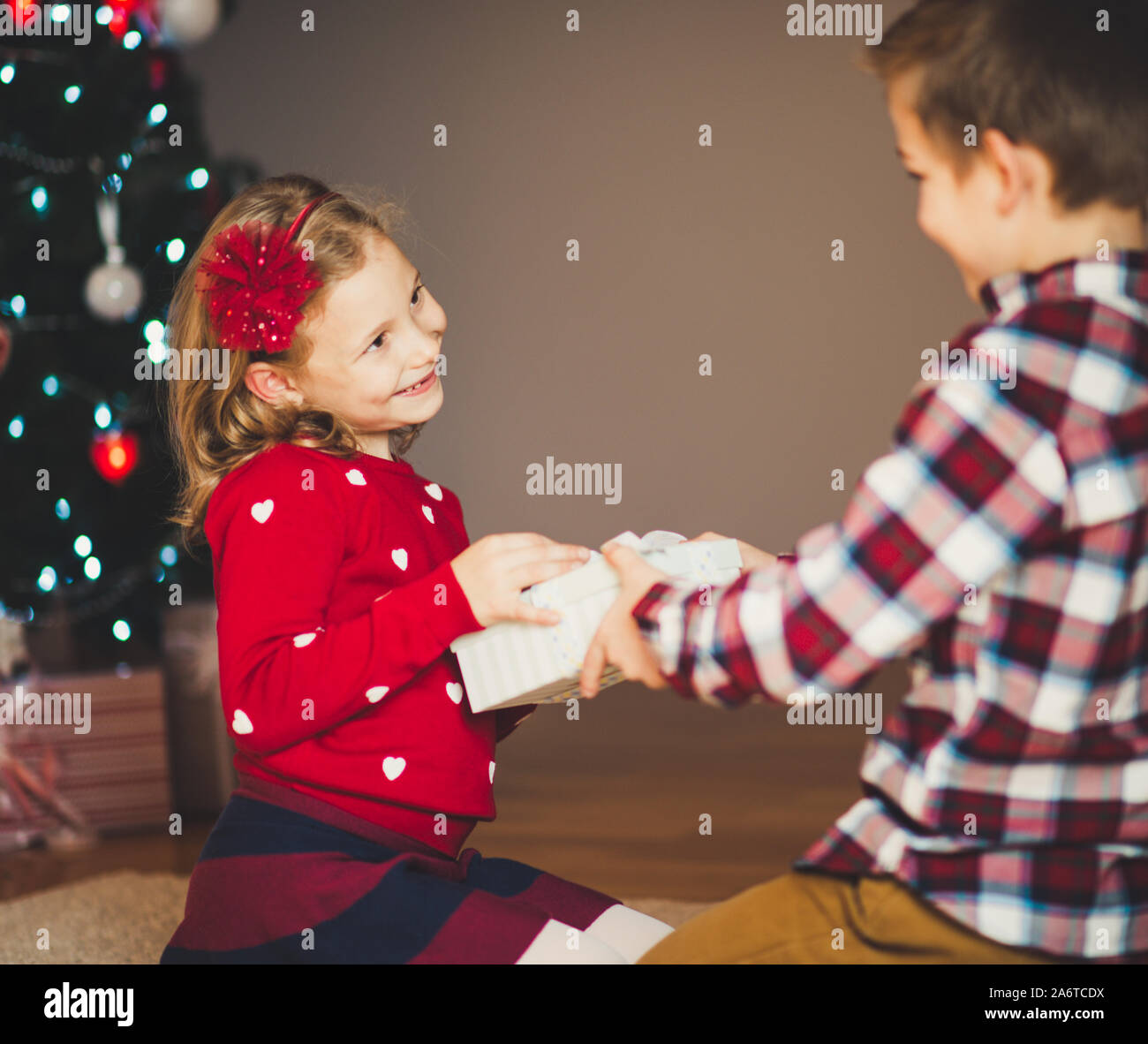 Two happy children in new year eve with presents near New Year Tree at ...