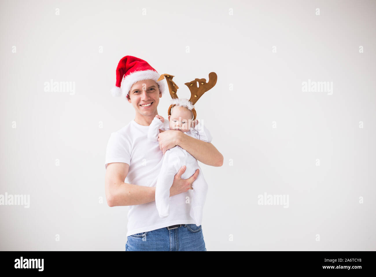 My first Christmas. Dad in santa hat holding his baby girl daughter ...