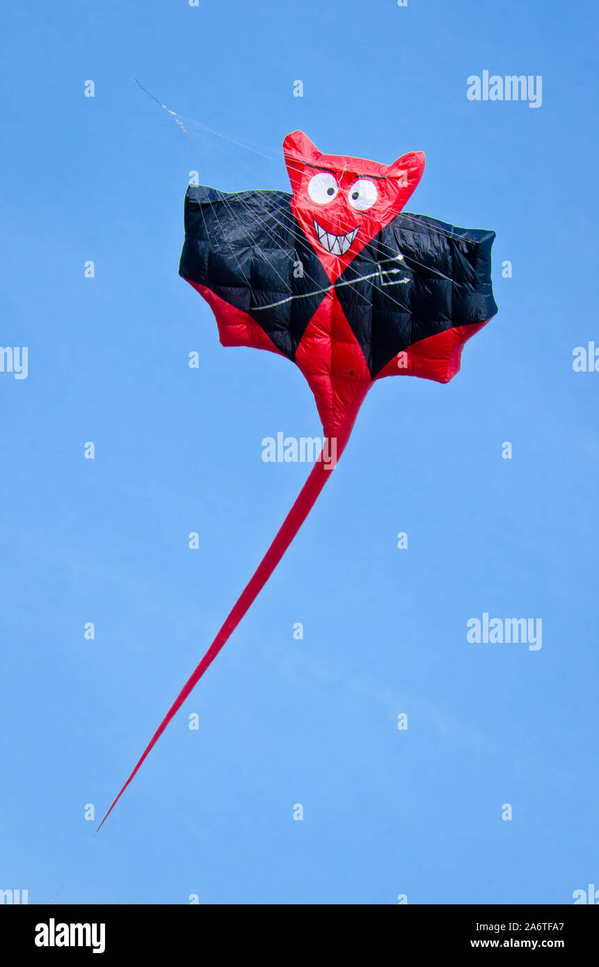 A beautiful, colourful stunt kite, in the blue sky, high up in the wind ...