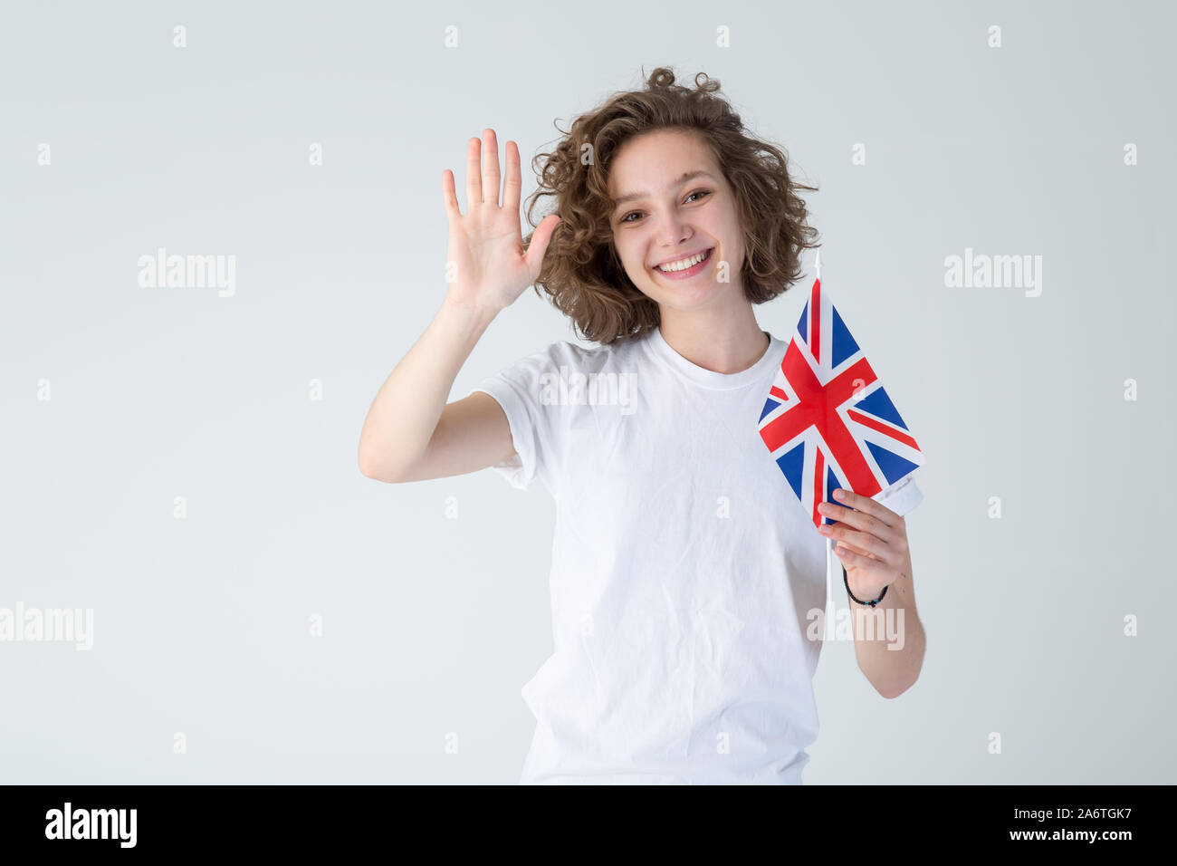 Hello! Young beautiful woman with curly hair with a Great Britain flag ...