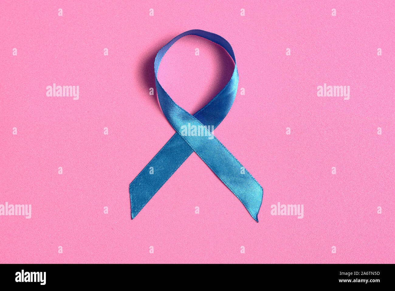 Blue ribbon on pink isolated background, international cancer prostate ...