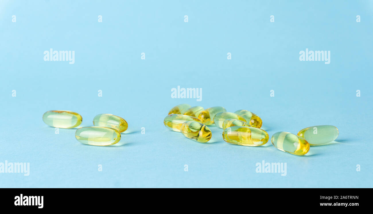 Fish oil (fish fat) capsules. Omega 3 vitamins in yellow gelatin ...