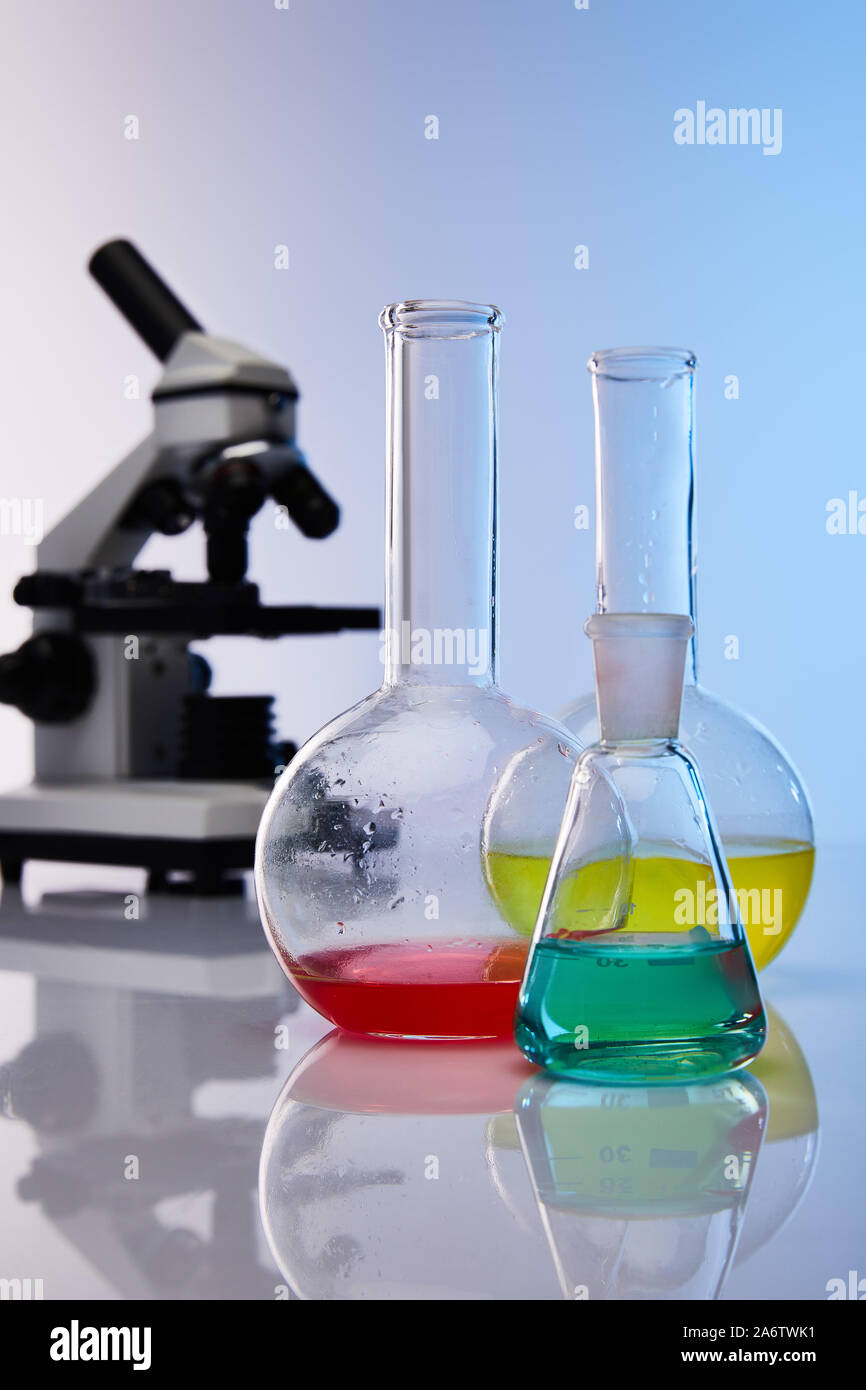 selective focus of glass flasks with colorful liquid near microscope ...