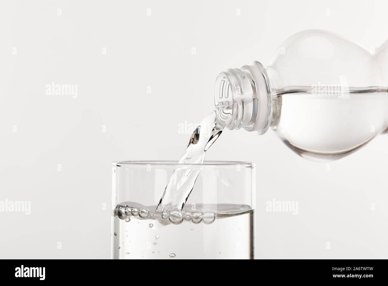 clear fresh water pouring into glass from bottle isolated on white Stock Photo - Alamy