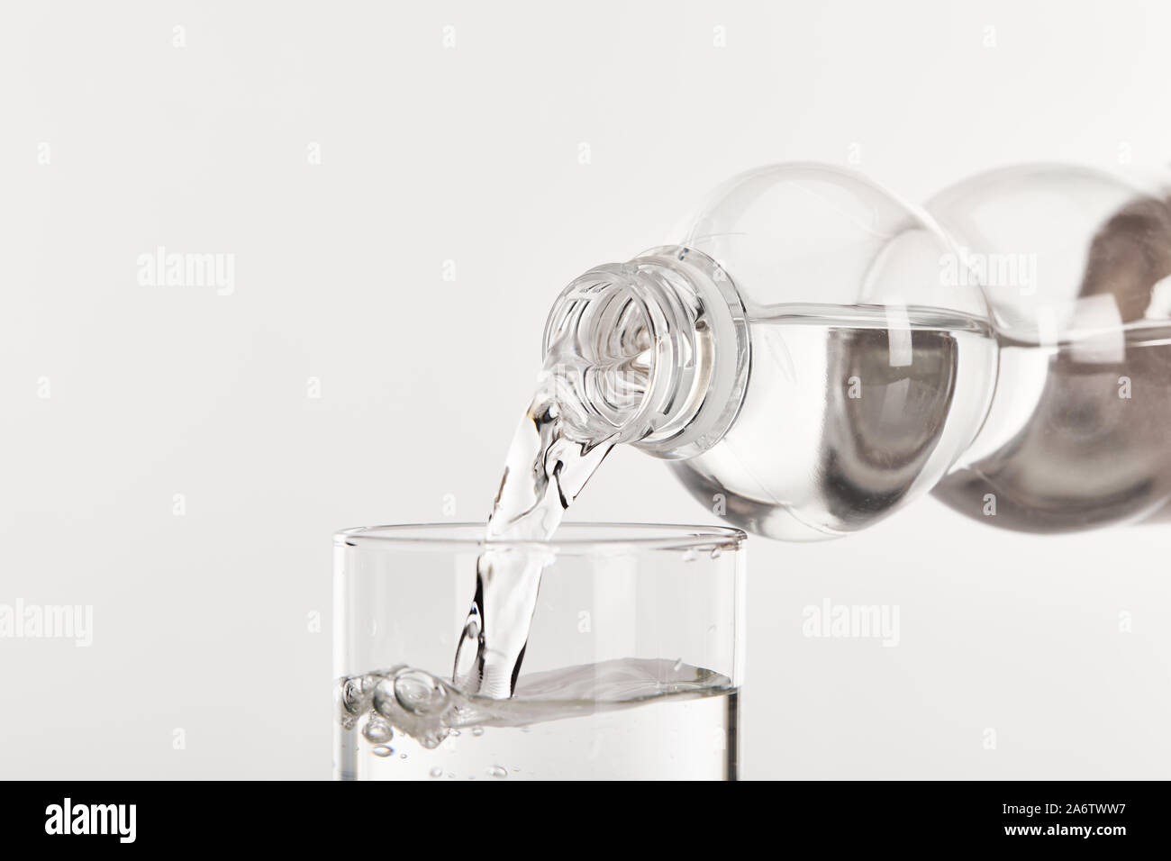clear fresh water pouring into glass from bottle isolated on white Stock Photo - Alamy