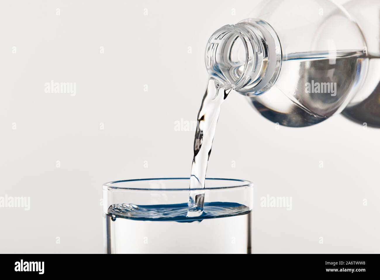 clear fresh water pouring into glass from bottle isolated on white ...