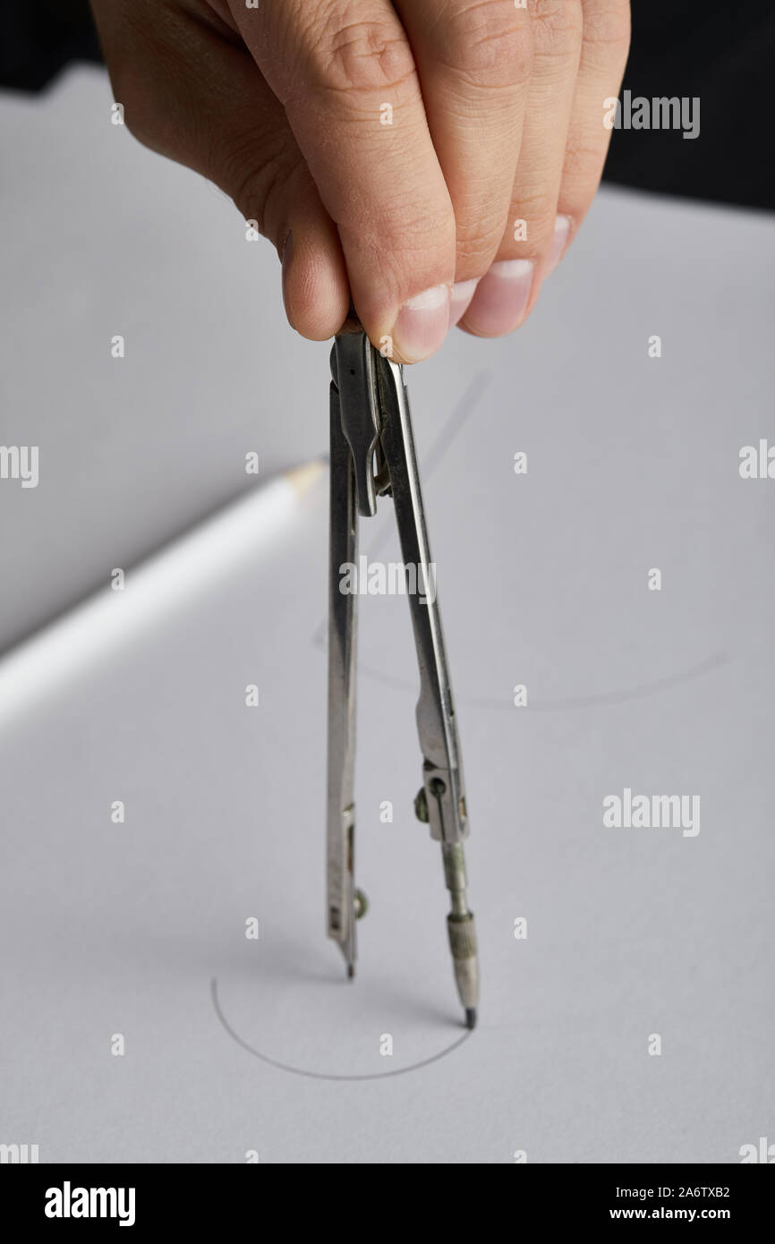 cropped view of man drawing circle on paper with compass Stock Photo ...