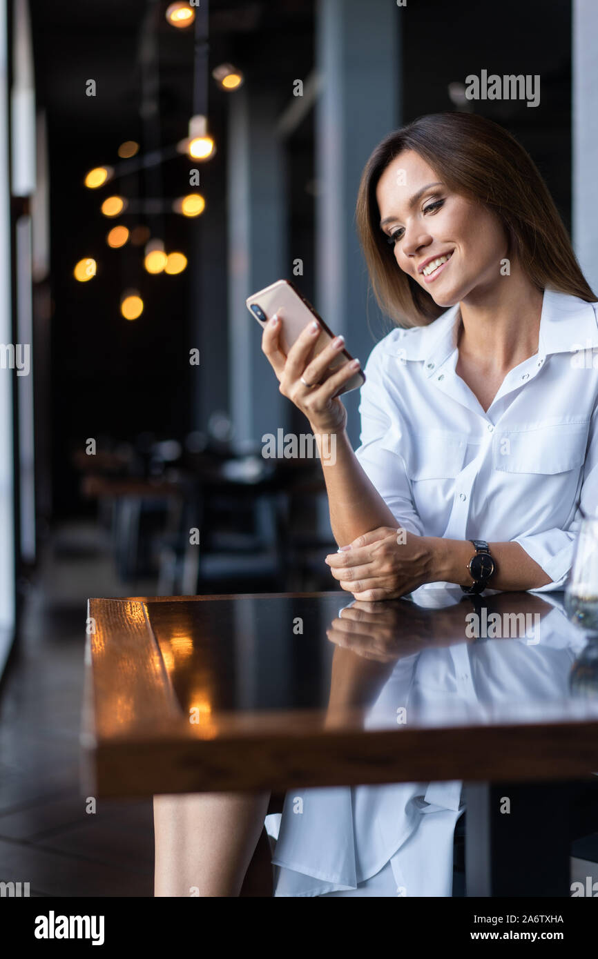 Young businesswoman using phone in coffee shop Stock Photo - Alamy