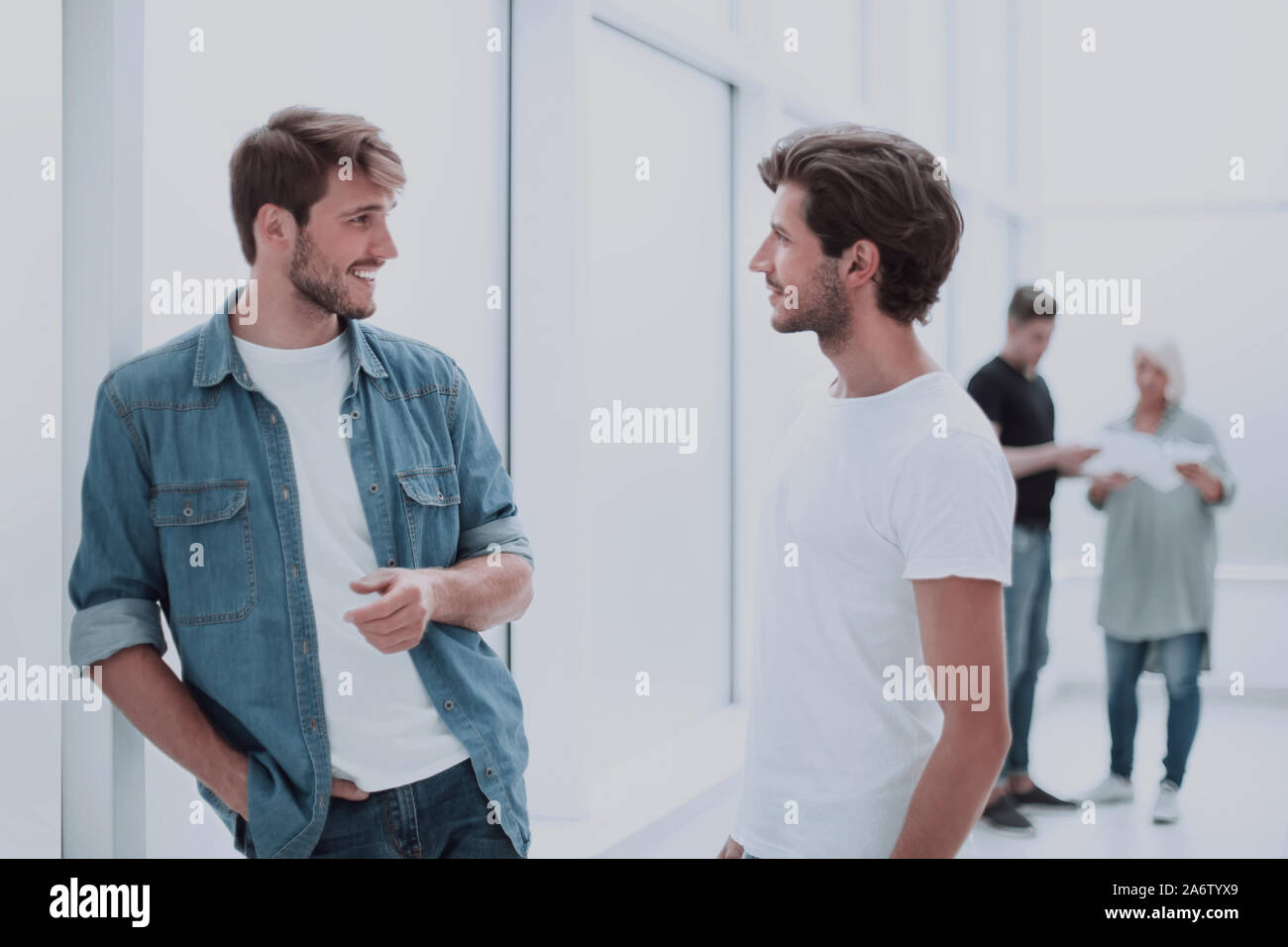 two colleagues talking standing in the office corridor Stock Photo - Alamy two colleagues talking standing in the office corridor Stock Photo - Alamy