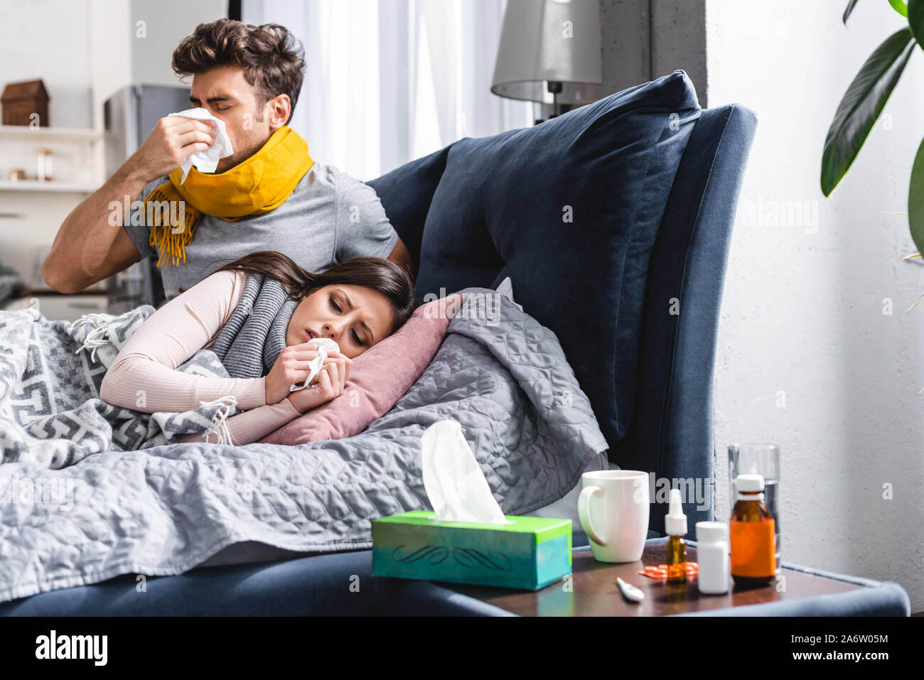 sick girlfriend and handsome boyfriend sneezing and holding napkins ...