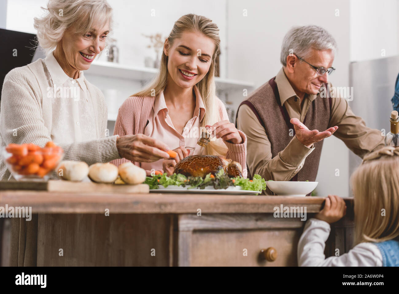 family members serving turkey and smiling in Thanksgiving day Stock ...