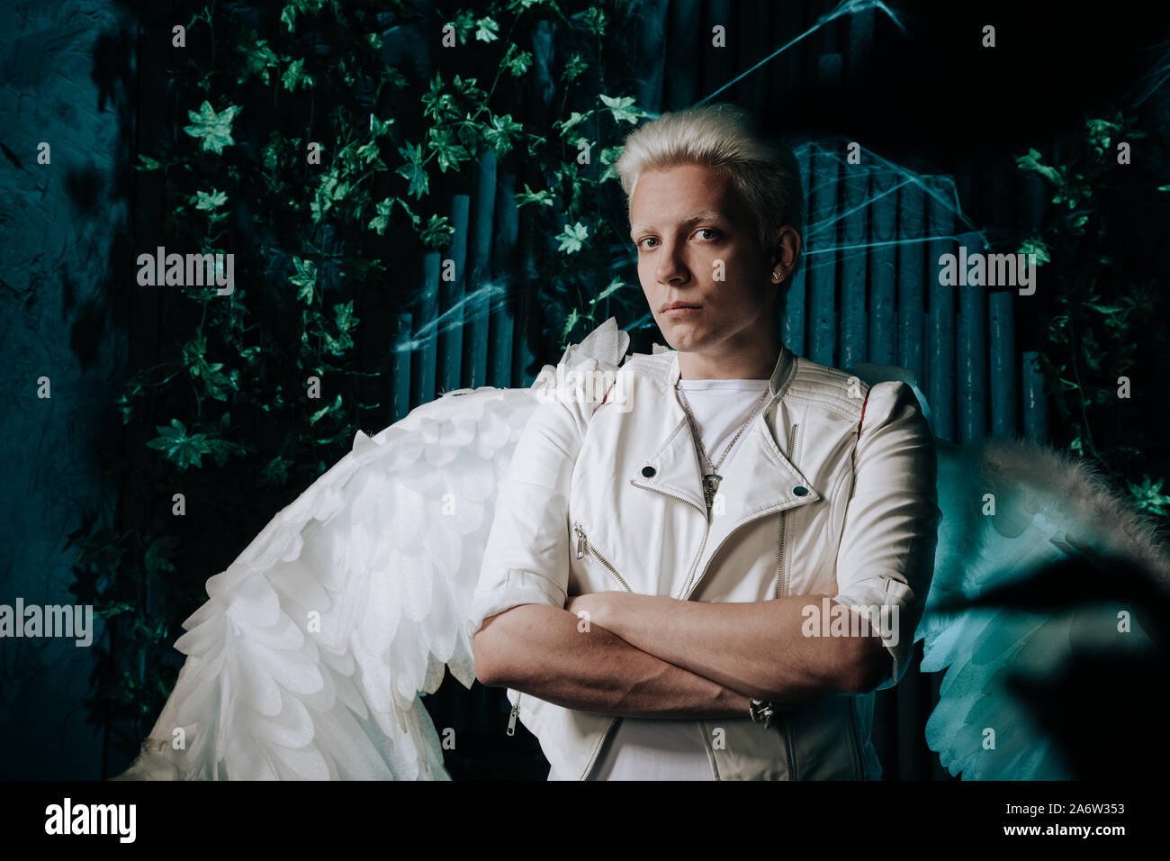 A portrait of a man with big feathered wings against a dark background ...
