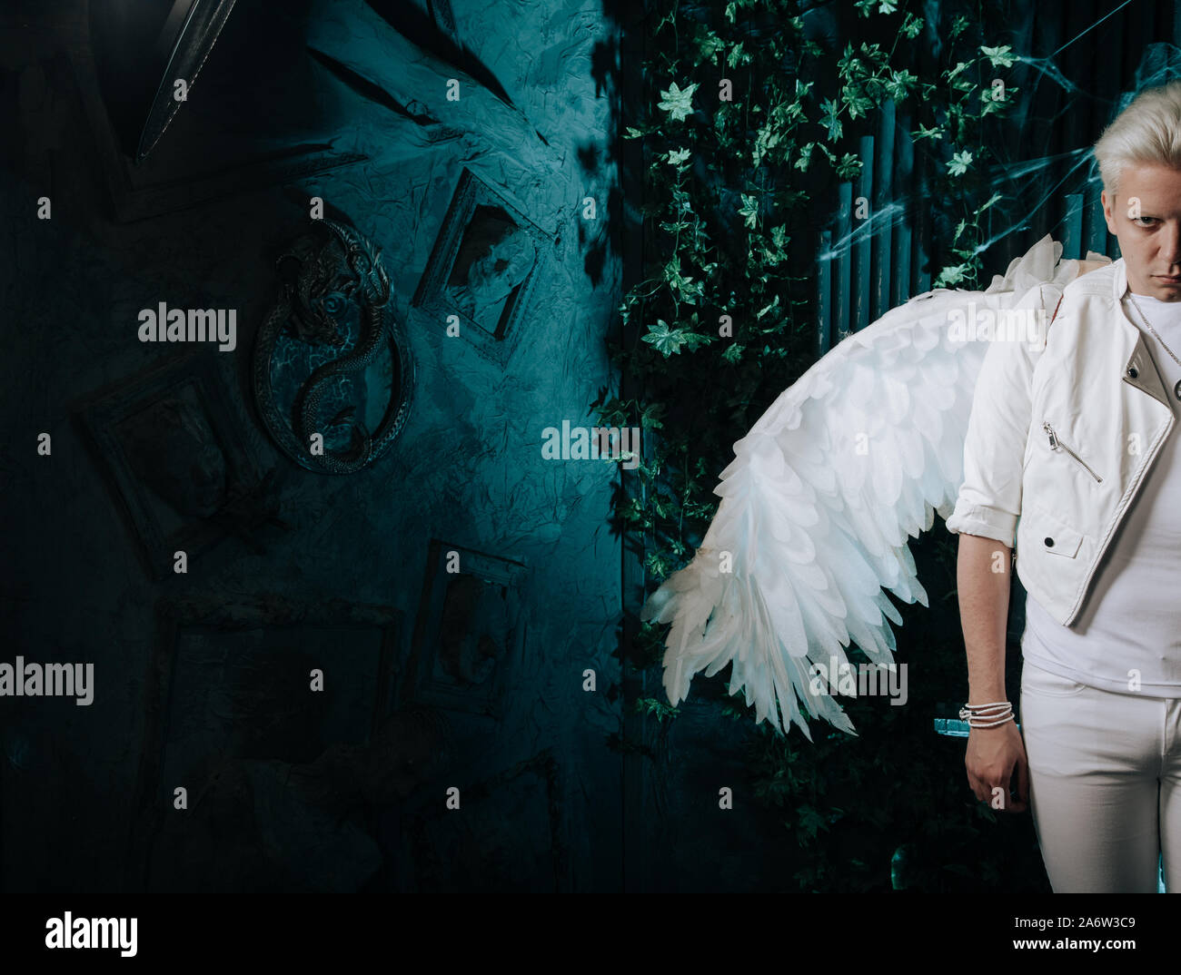 A portrait of a man with big feathered wings against a dark background ...