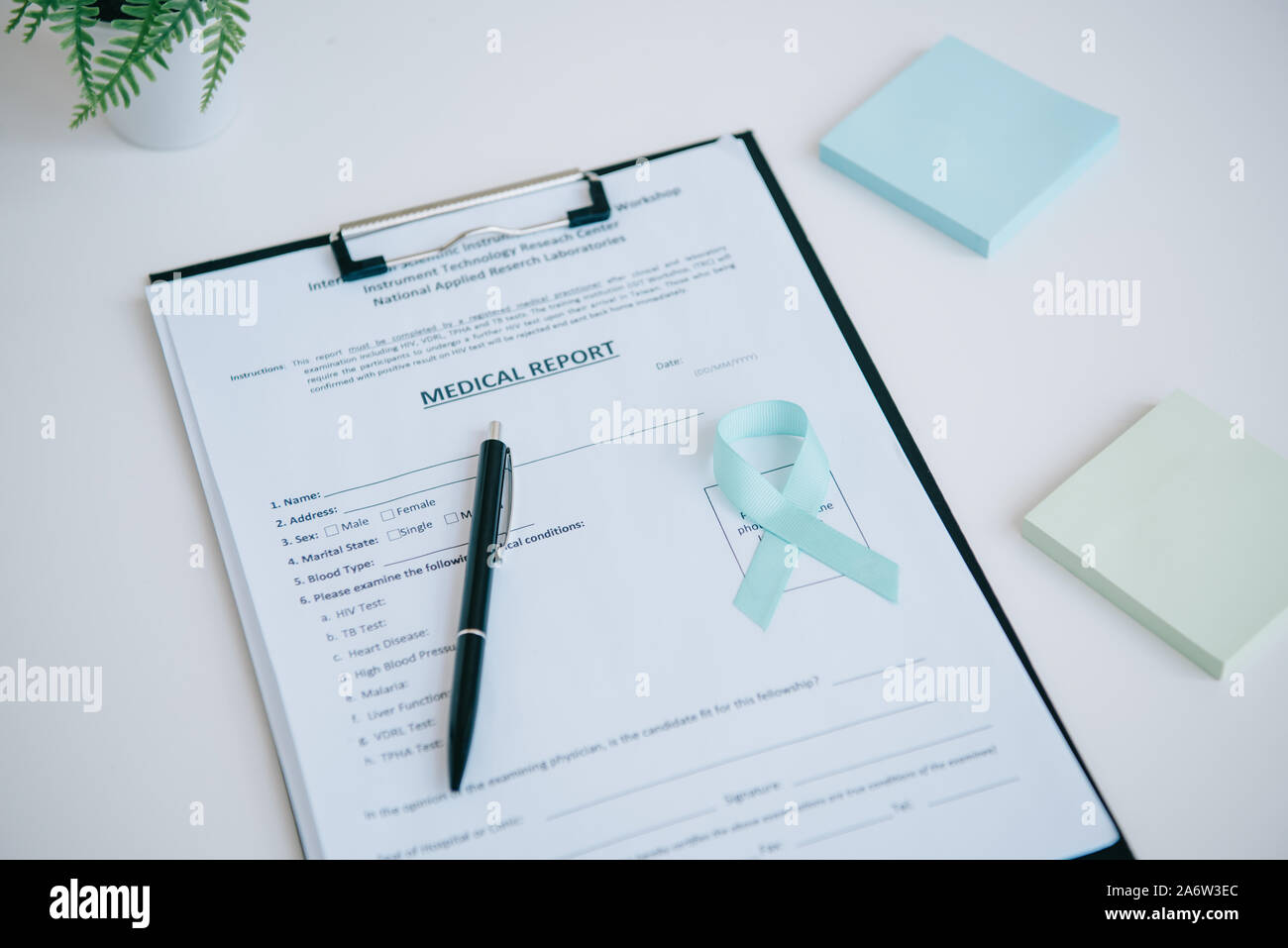 blue awareness ribbon on medical report near pen and sticky notes Stock ...