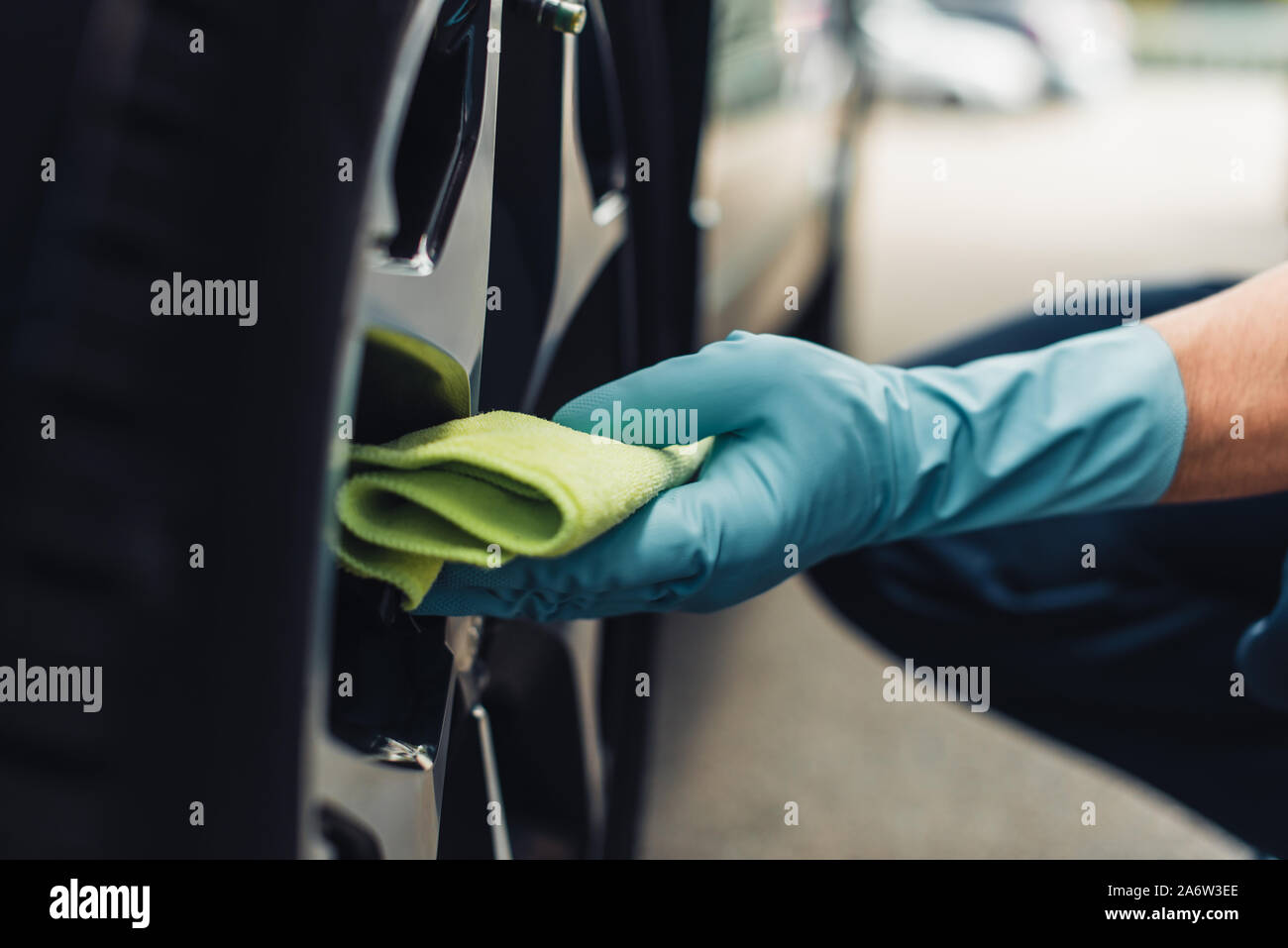 partial view of car cleaner wiping car wheel with rag Stock Photo - Alamy