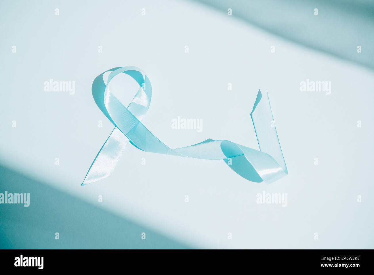 blue awareness ribbon on white background with shadows Stock Photo - Alamy