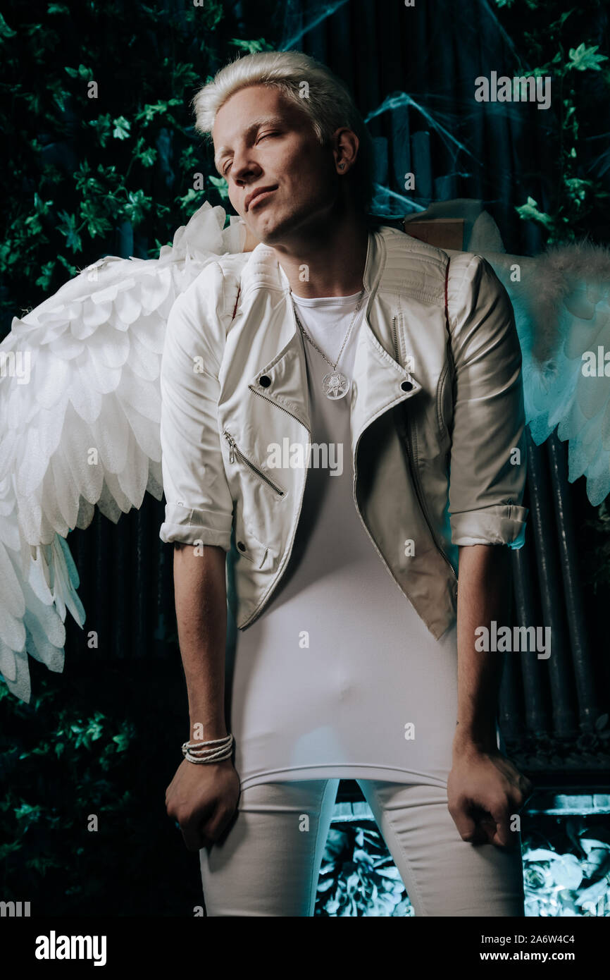 A portrait of a man with big feathered wings against a dark background ...