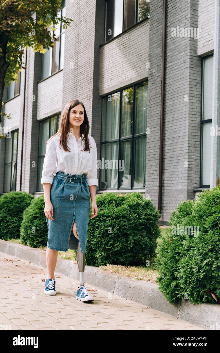 full length view of smiling disabled woman walking on street Stock ...