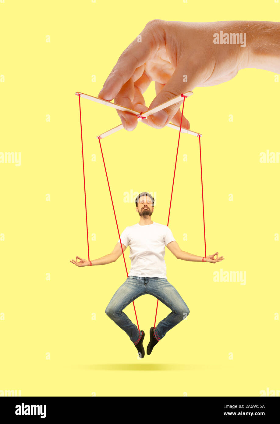 Man like a puppet in somebodies hands on yellow background. Concept of ...