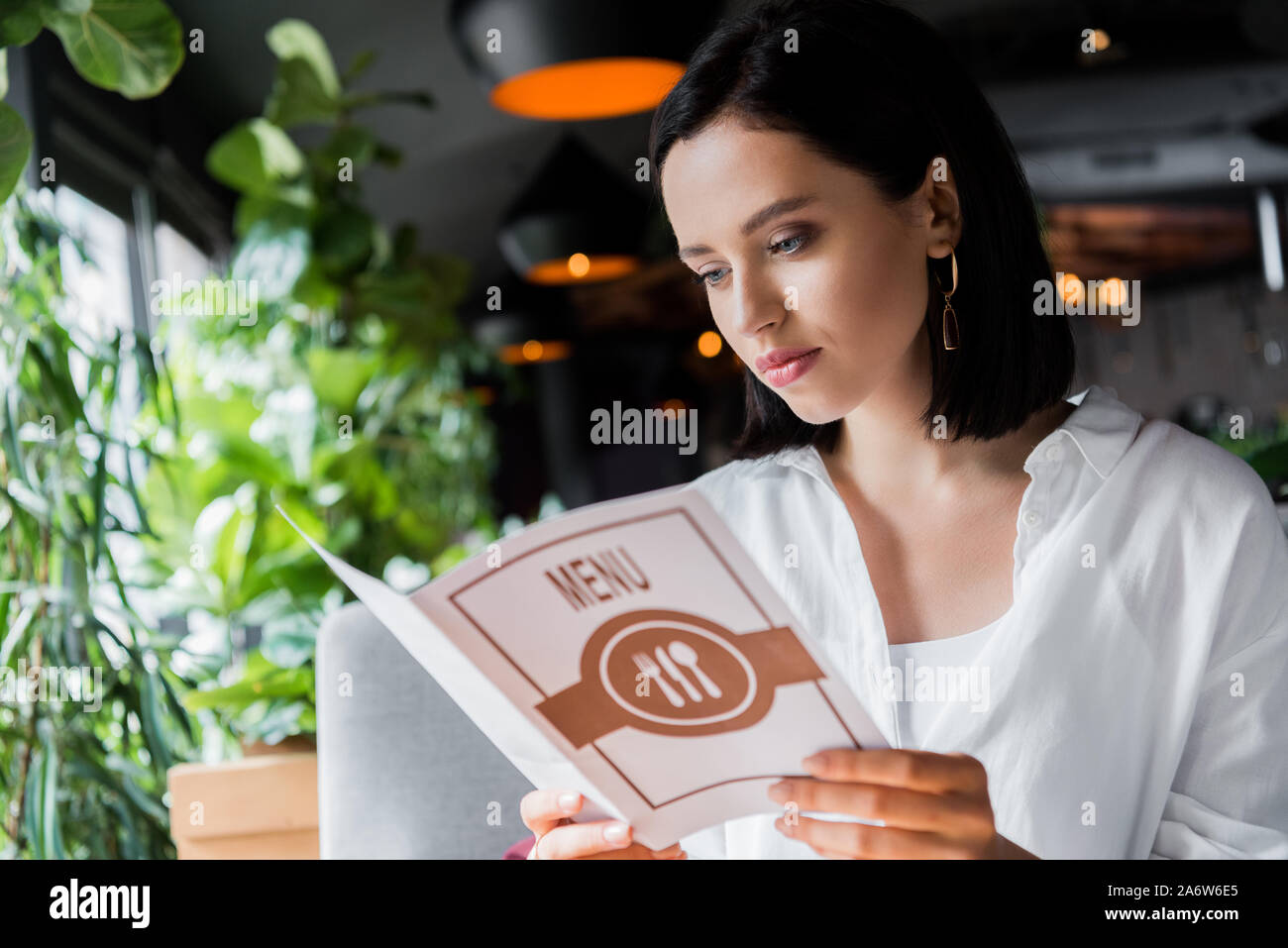 attractive young woman looking at menu in restaurant Stock Photo - Alamy