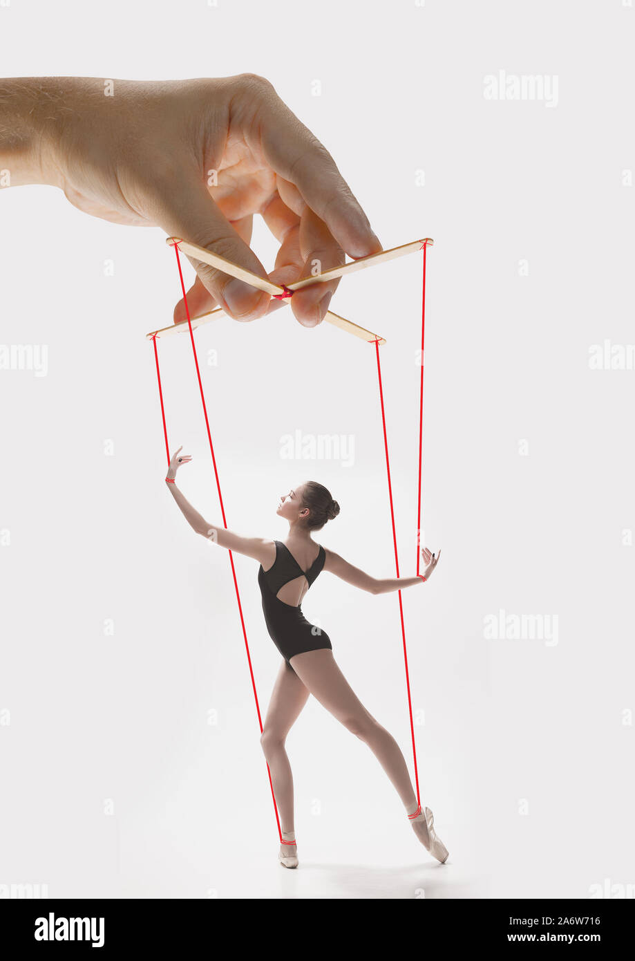 Woman like a puppet in somebodies hands on grey background. Concept of ...