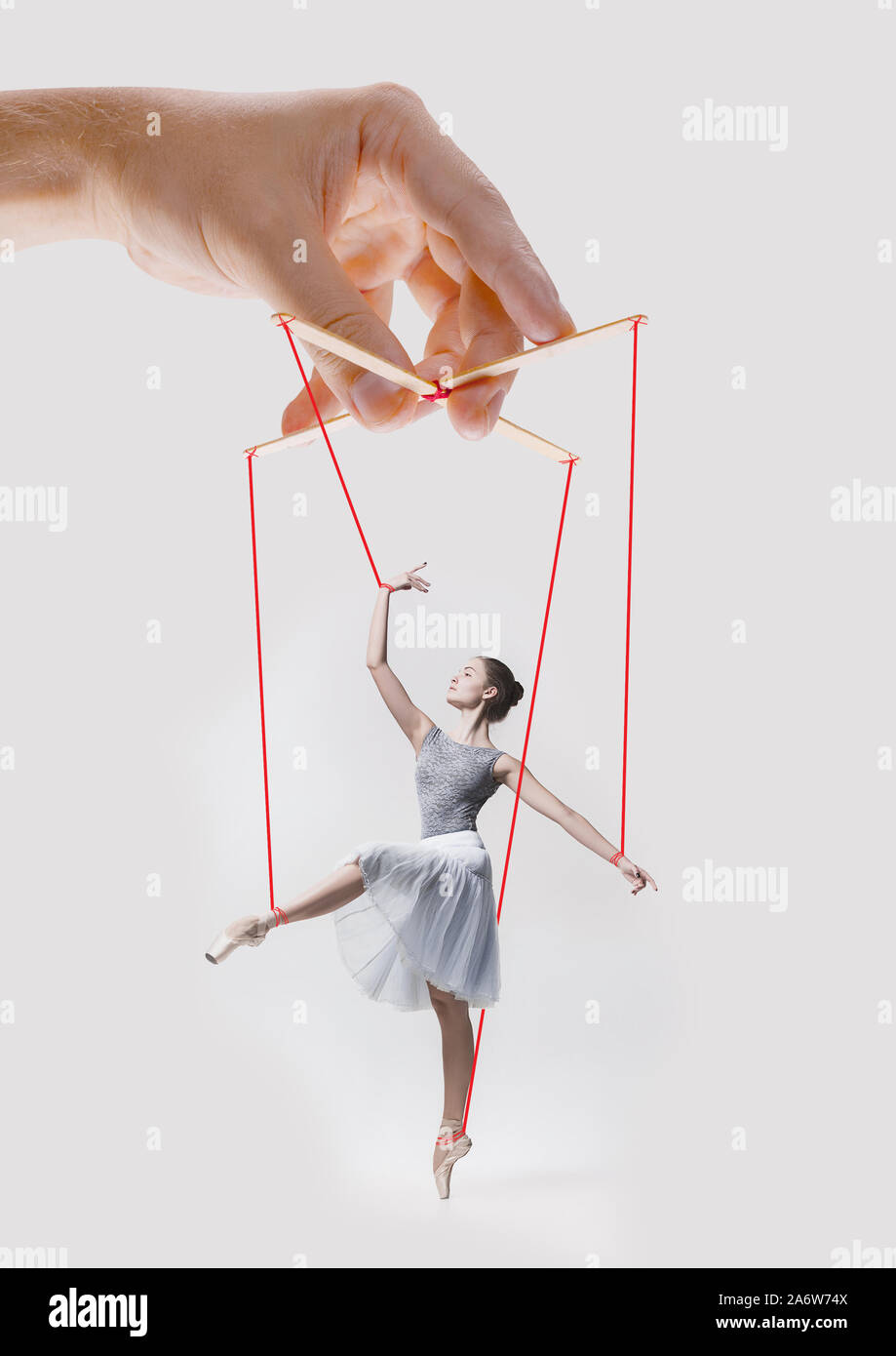 Woman like a puppet in somebodies hands on grey background. Concept of ...