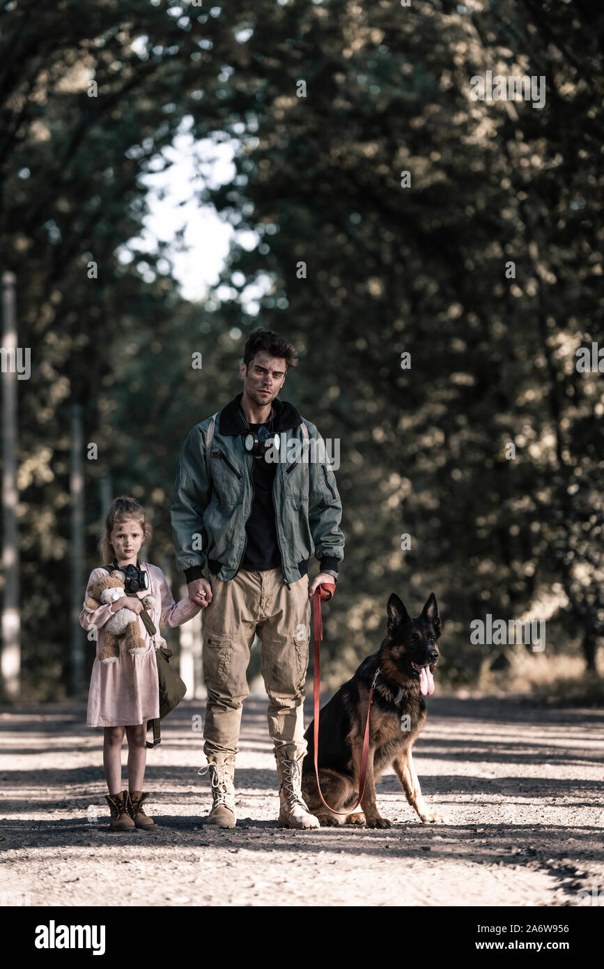 handsome man holding hands with kid near german shepherd dog, post ...