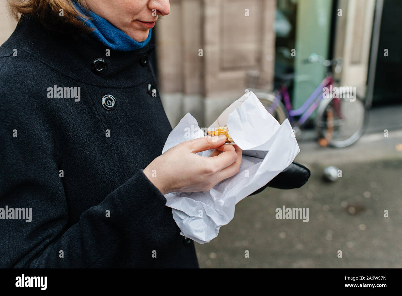Side view of woman eating traditional Alsatian tarte with pork meat ...