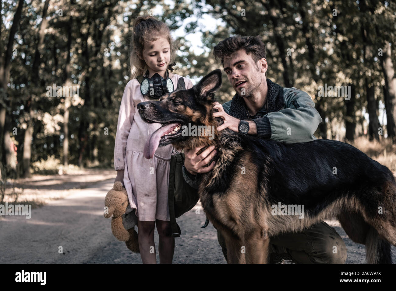 handsome man touching german shepherd dog near child, post apocalyptic ...