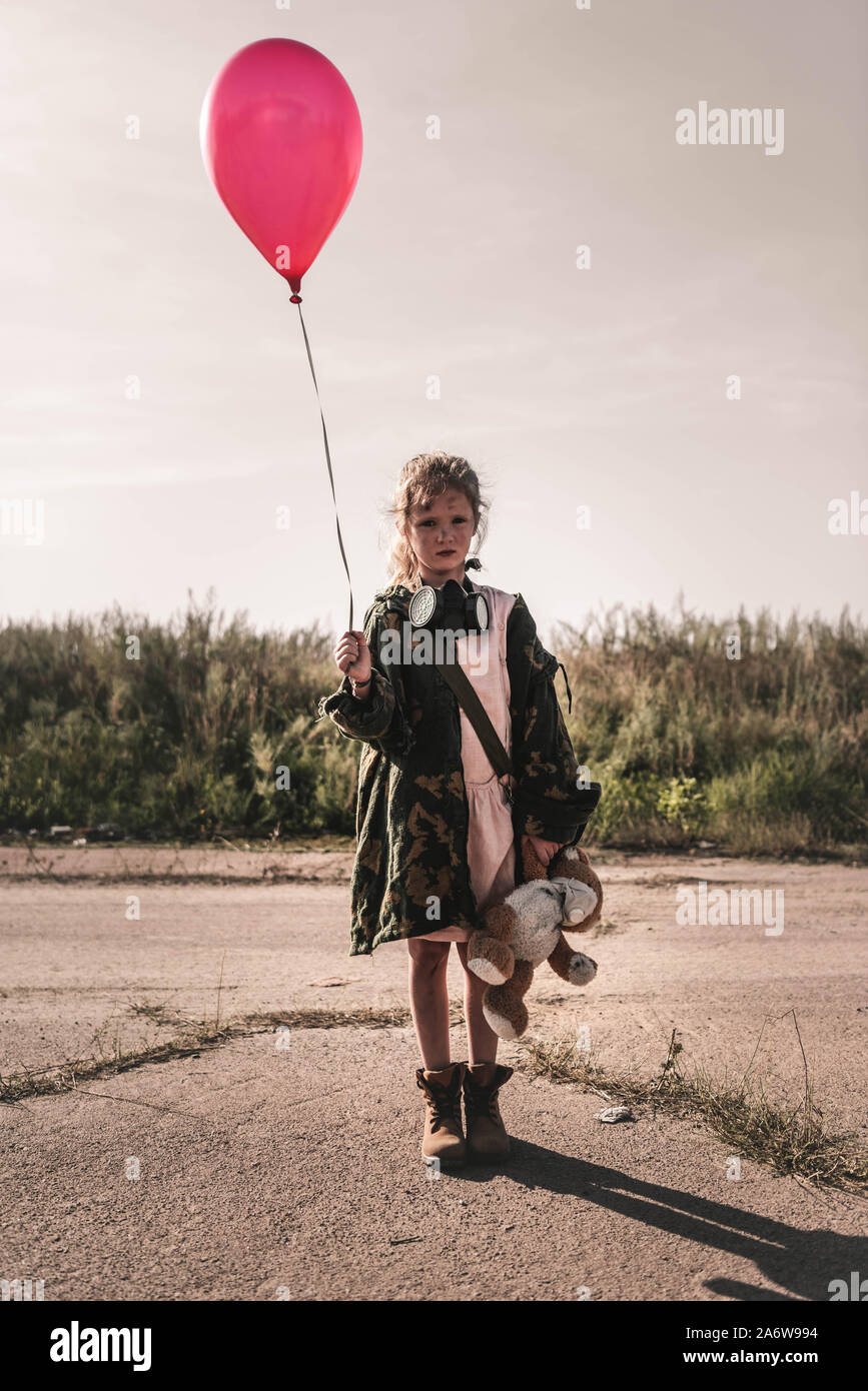 cute kid with gas mask holding red balloon, post apocalyptic concept ...