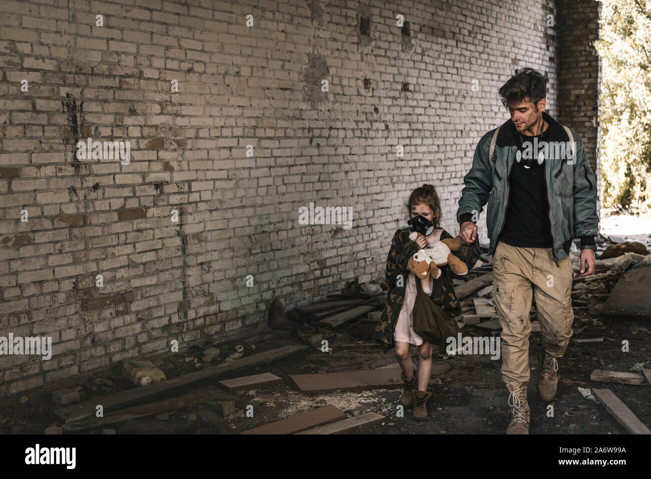 man holding hands with kid while walking on street in chernobyl, post ...