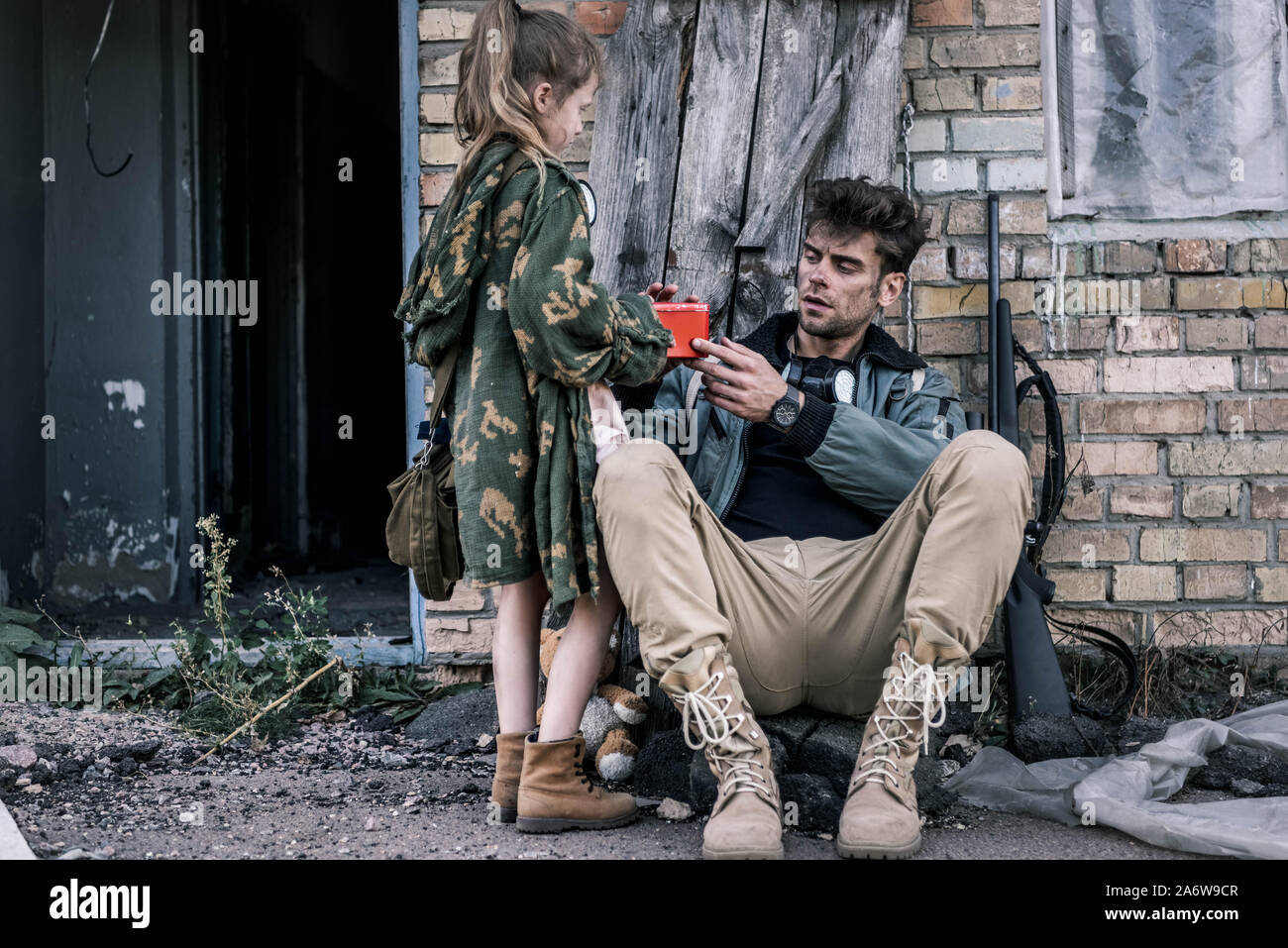 kid standing near armed man with first aid kit, post apocalyptic ...