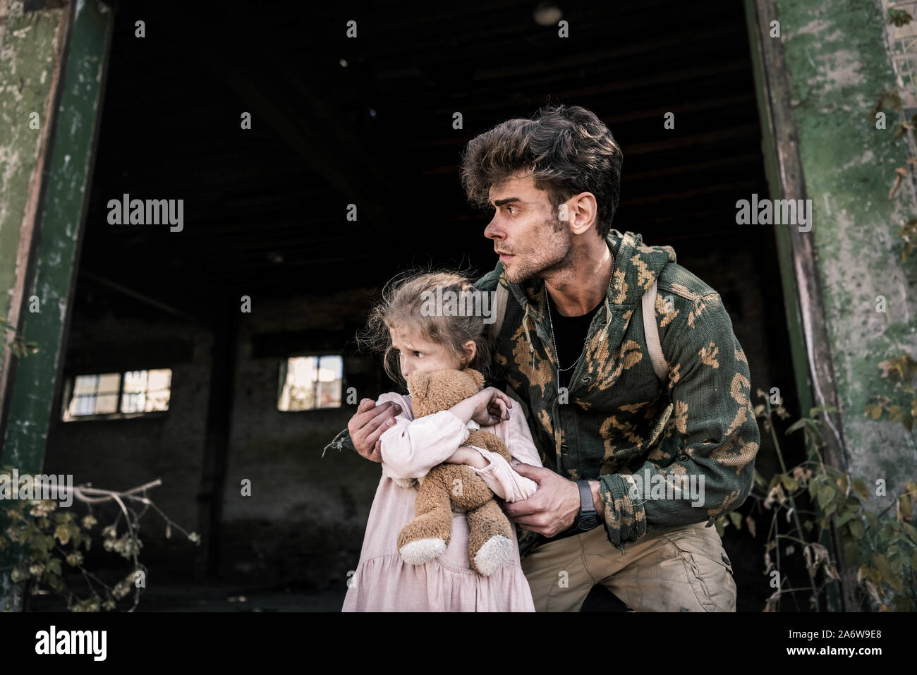 handsome man standing with cute child outside, post apocalyptic concept ...